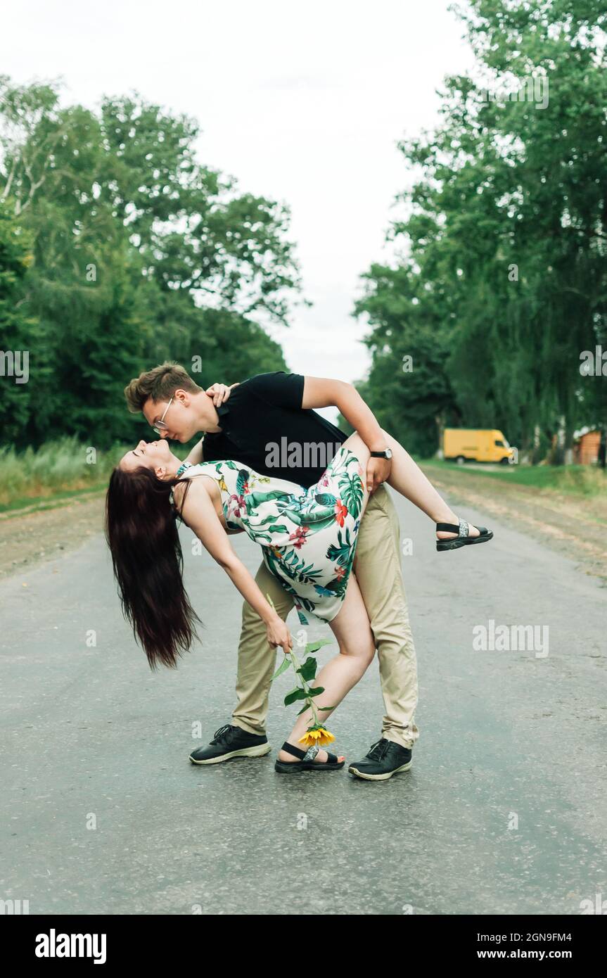 Vertical shot of a happy romantic couple missing and posing for ...