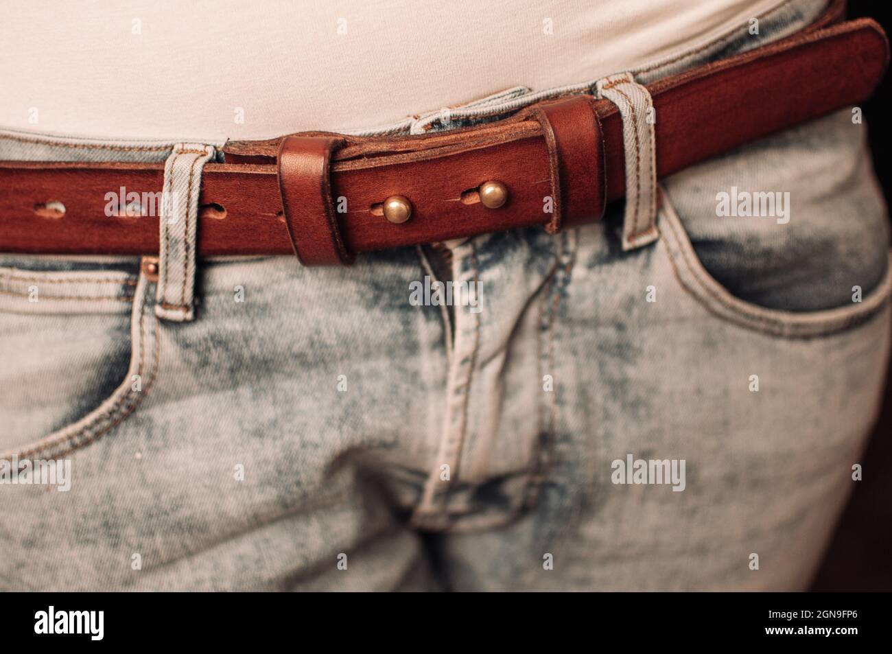 Person wearing an old leather belt Stock Photo - Alamy