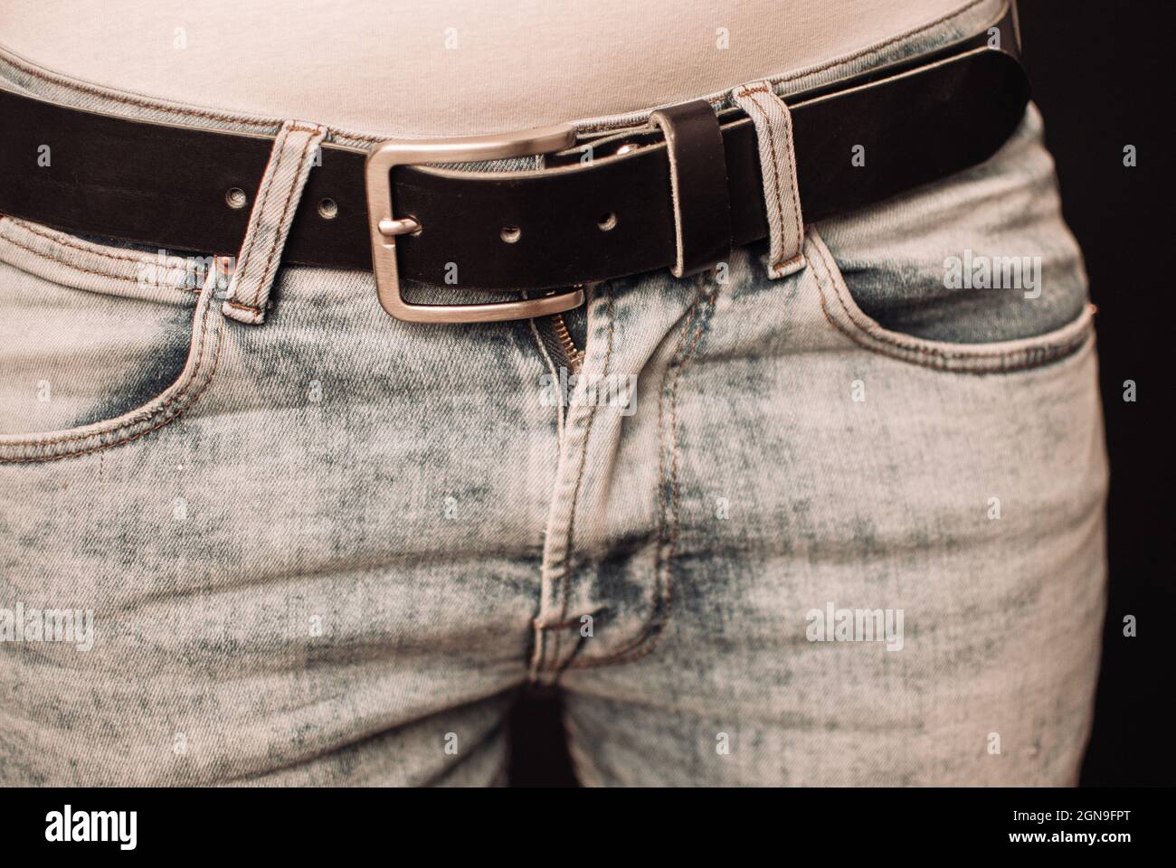 Person wearing an old leather belt Stock Photo - Alamy