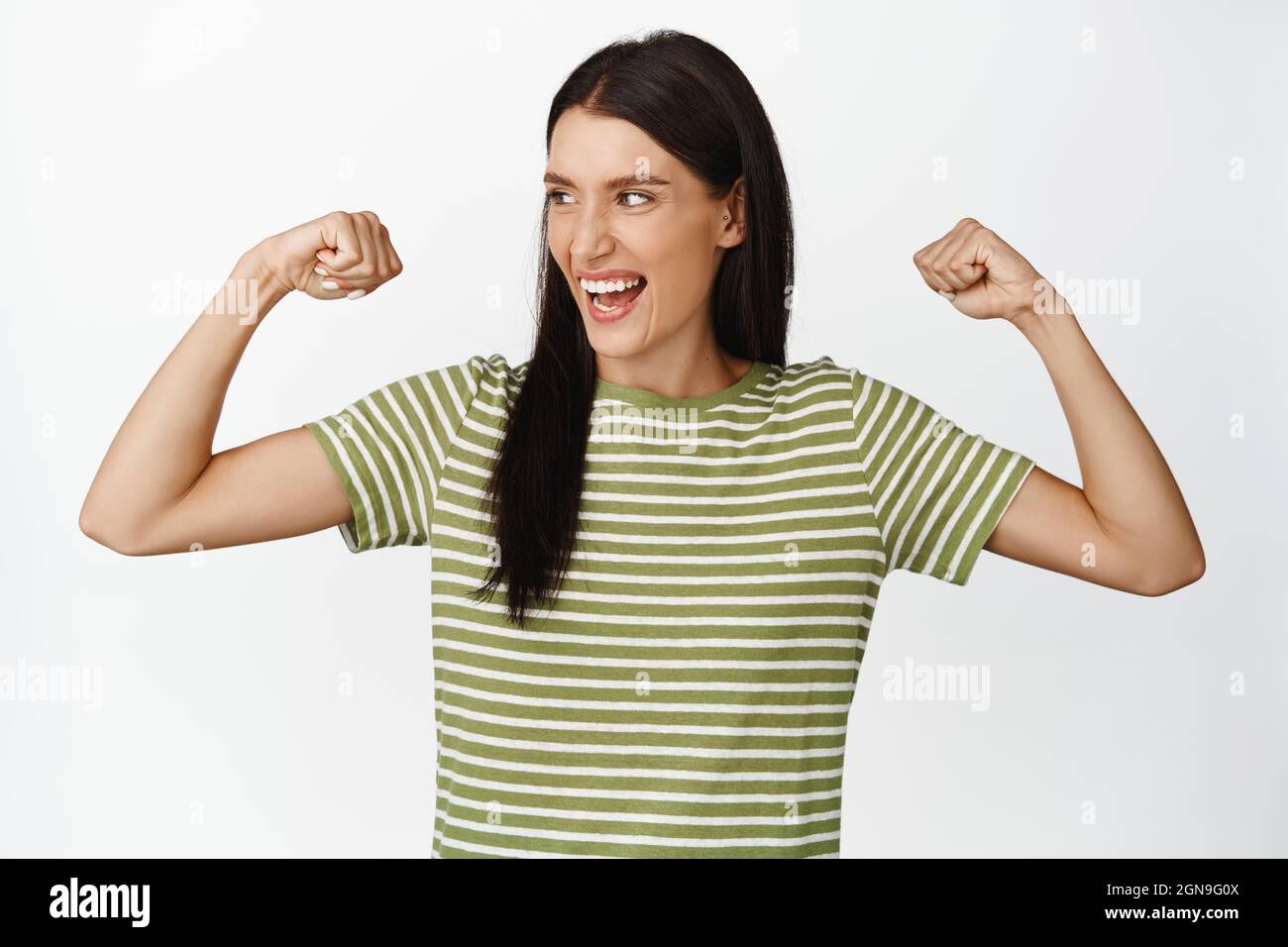 Empowered happy woman feeling strong, flexing biceps, showing her ...