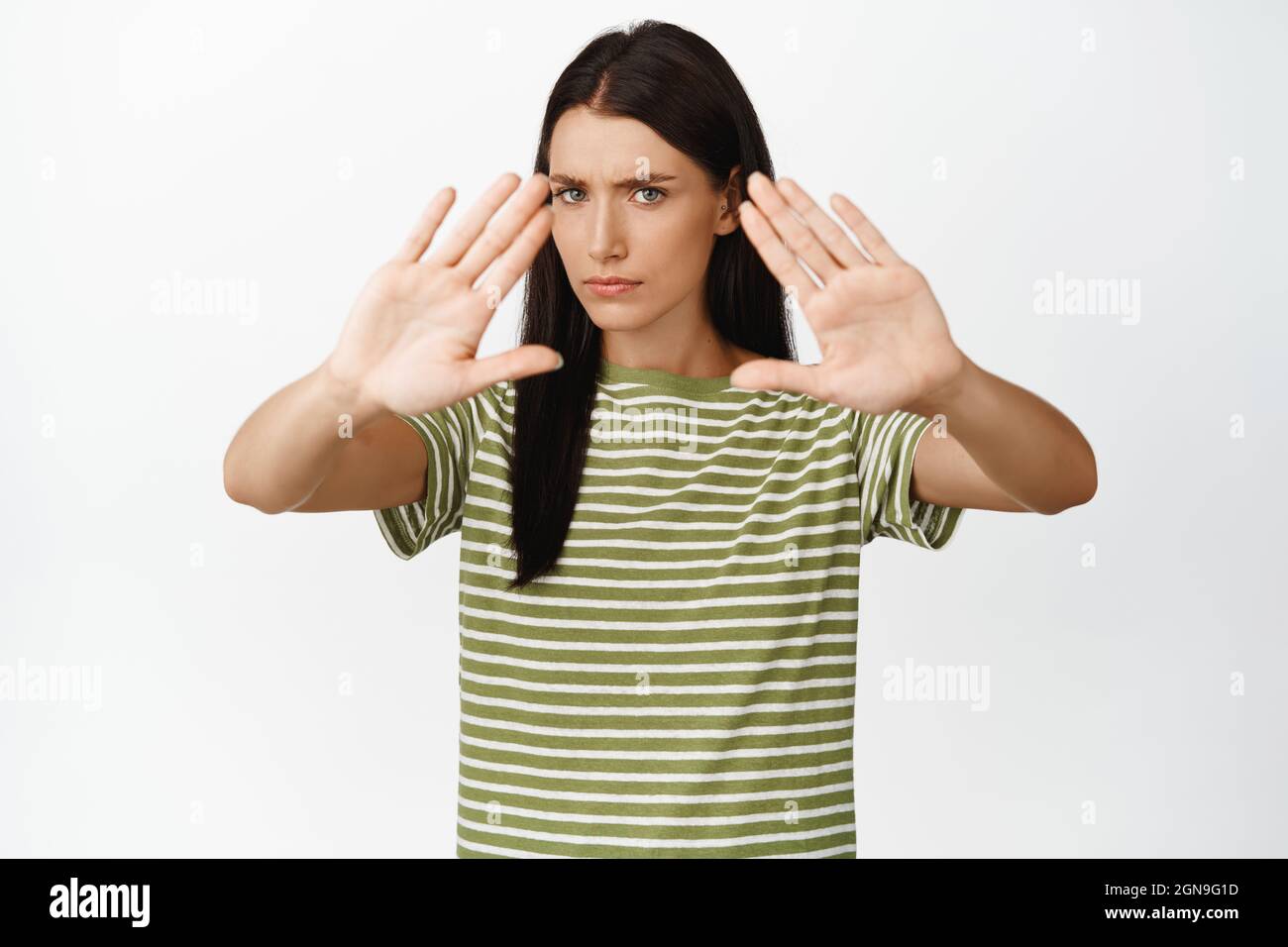 Serious woman stretch out hands in block, stopping, say no, frowning ...