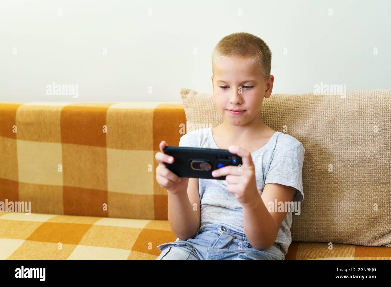 Close-up of cute little boy using smartphone looking at screen, curious ...