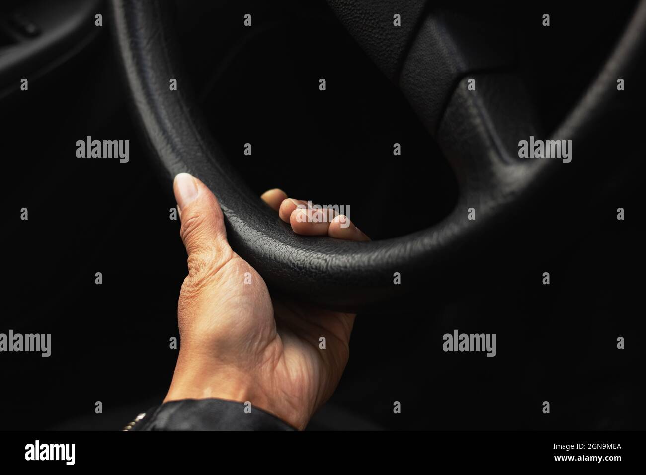 Hand on the steering wheel of a car close up Stock Photo - Alamy