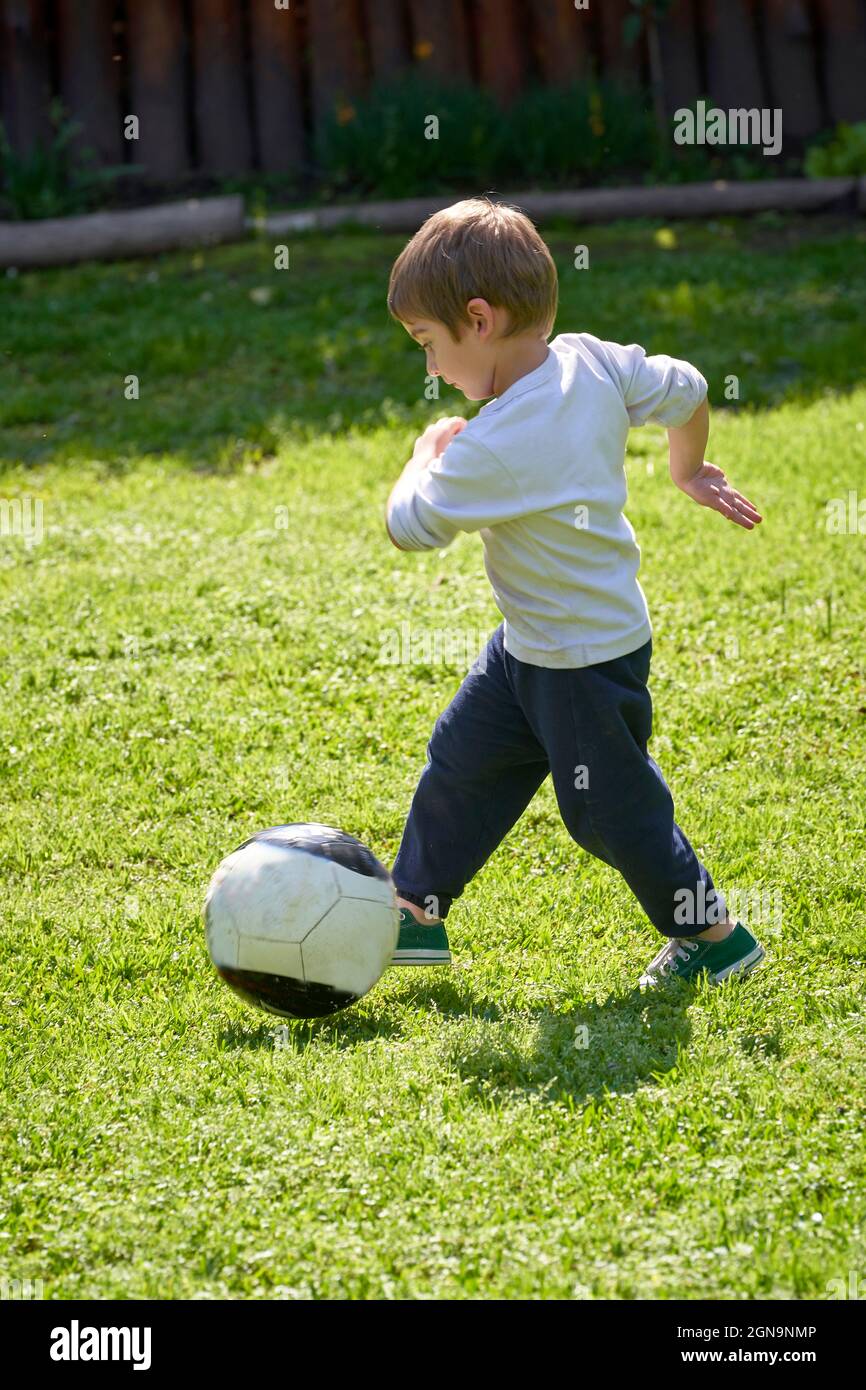 Boy Playing Soccer Full Length Of Happy Boy Playing Soccer In Garden