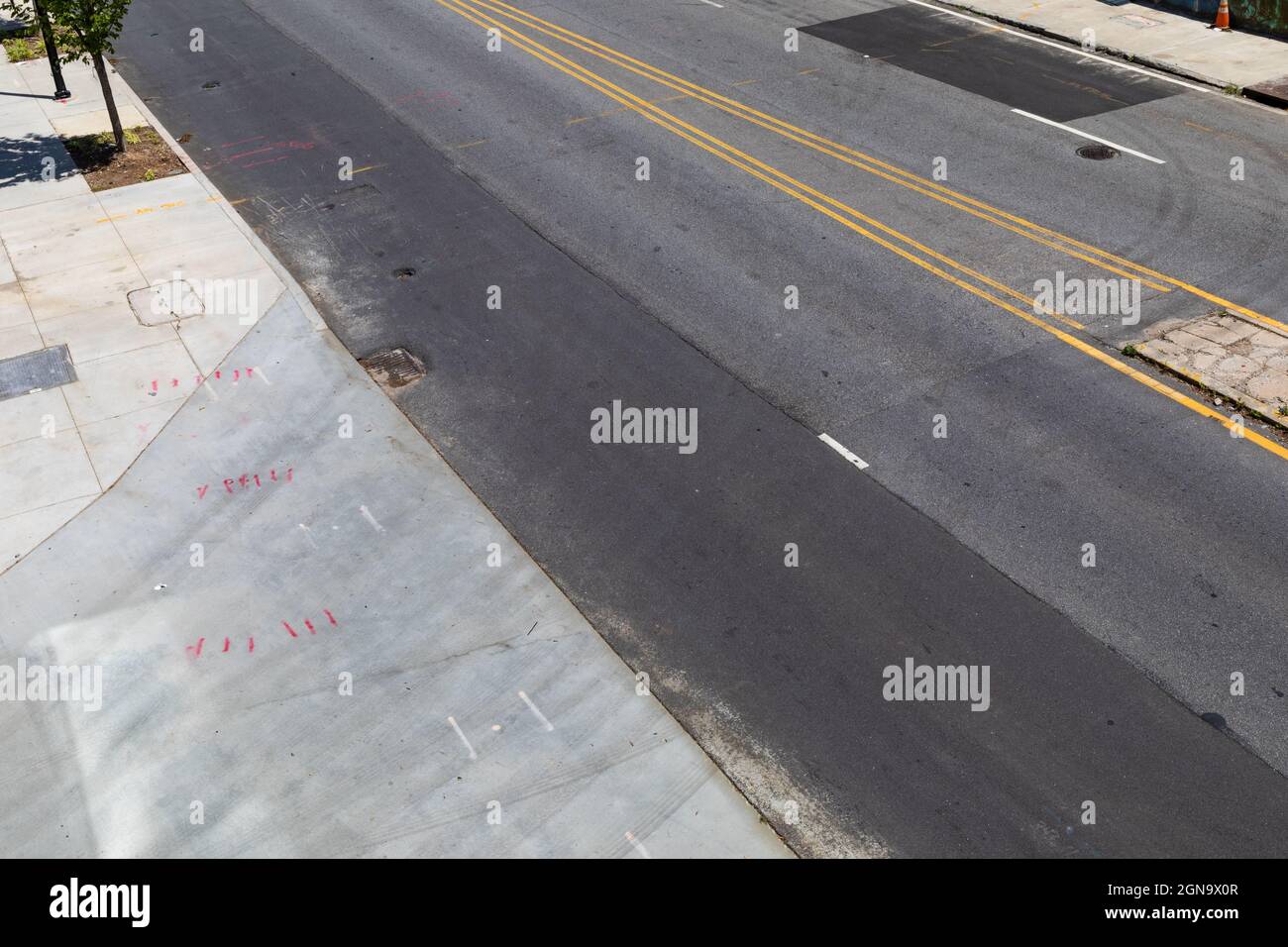 Urban street viewed from above, weathered and patched asphalt and ...