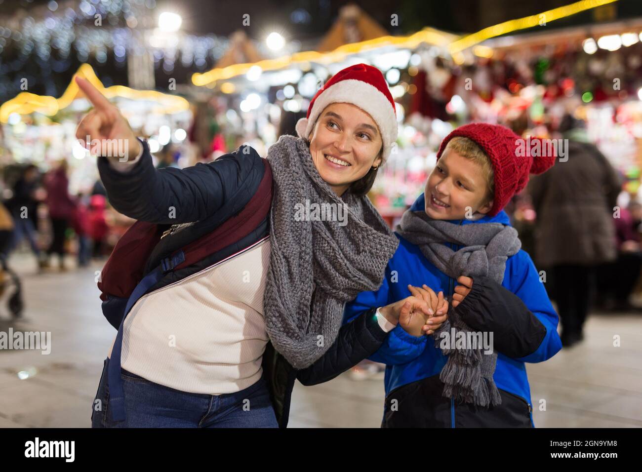 Happy tween boy and his mom walking at street Christmas fair Stock ...