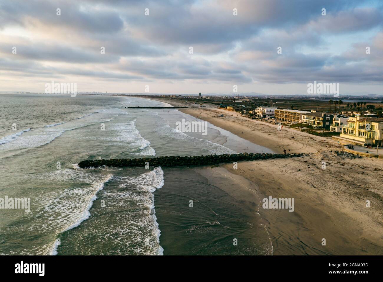 Surfers in ocean by jetty in Imperial Beach San Diego California ...