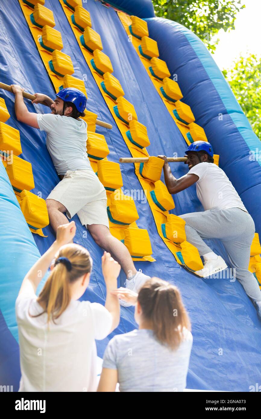 Males climbing on inflatable slide Stock Photo - Alamy