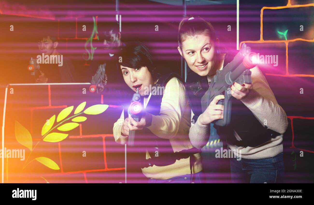 two emotional female laser tag players having fun in multination Stock ...