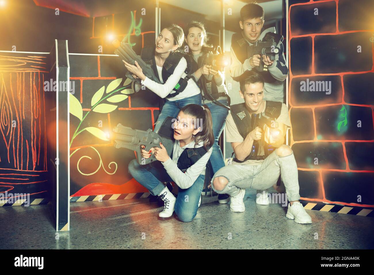 Five emotional young people play laser tag Stock Photo - Alamy