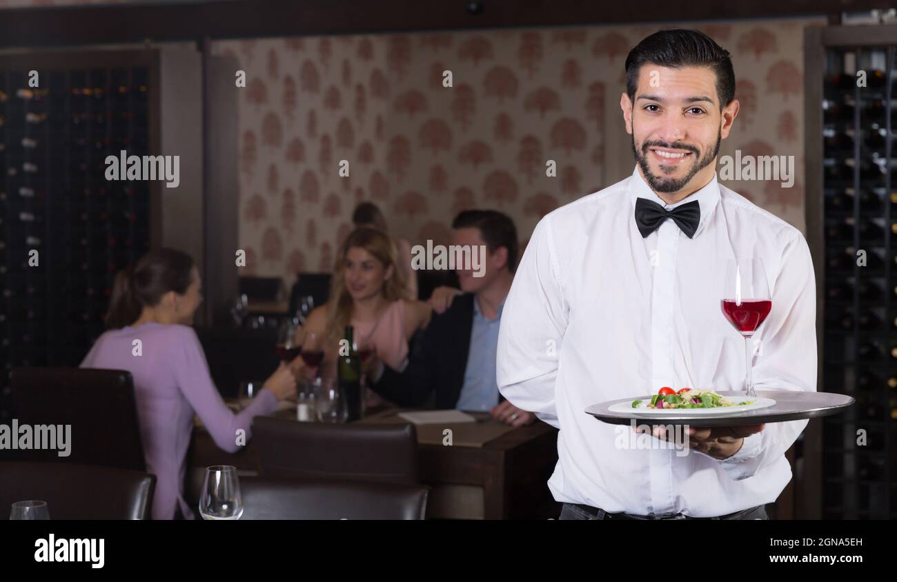 Glad waiter with tray welcoming to restaurant Stock Photo - Alamy