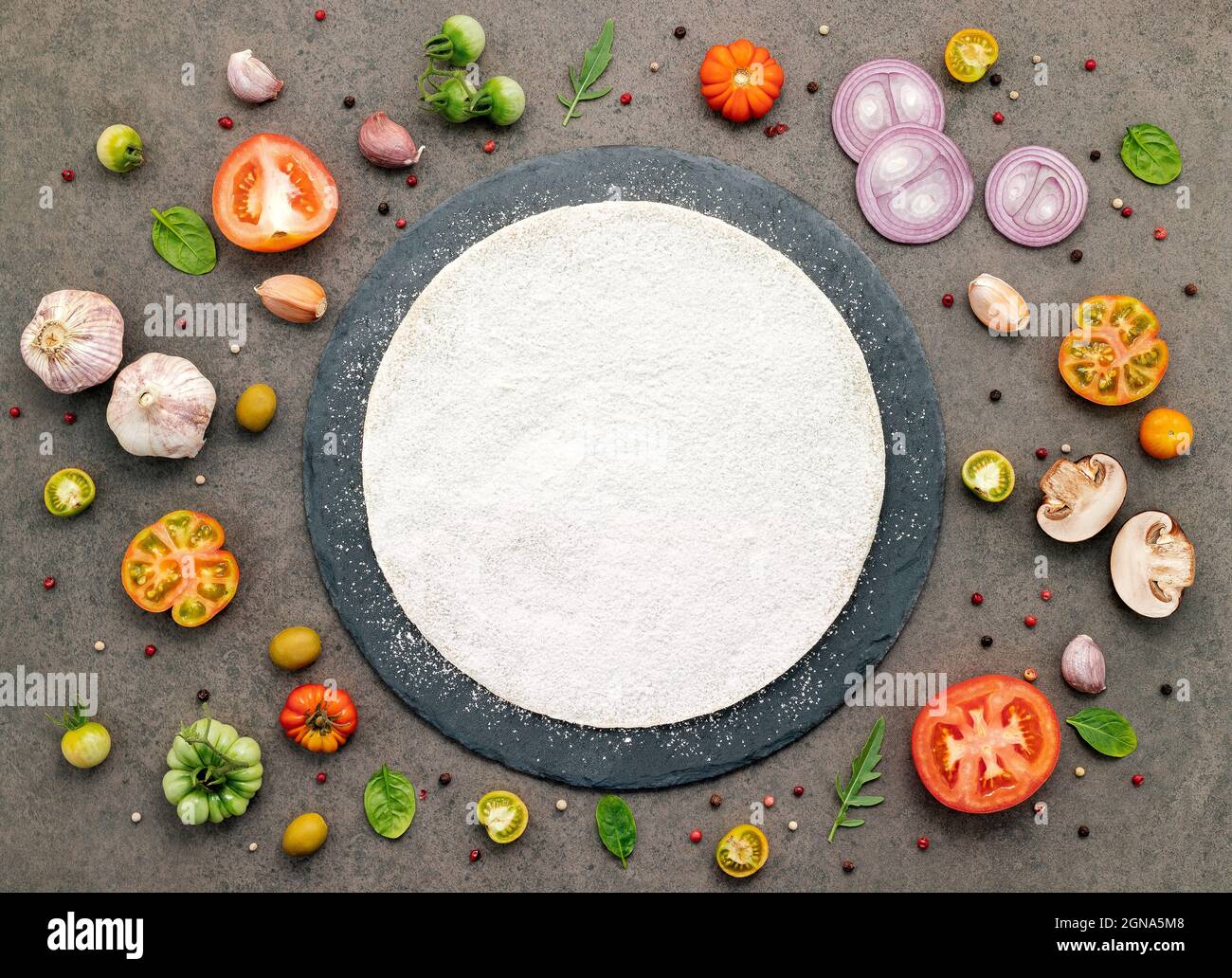 The ingredients for homemade pizza set up on dark stone background ...