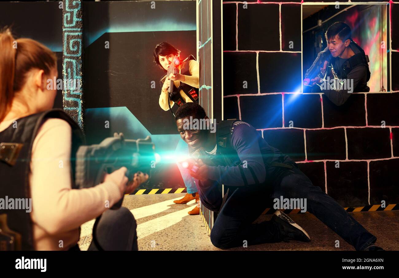 group of adult people with laser guns having fun Stock Photo - Alamy