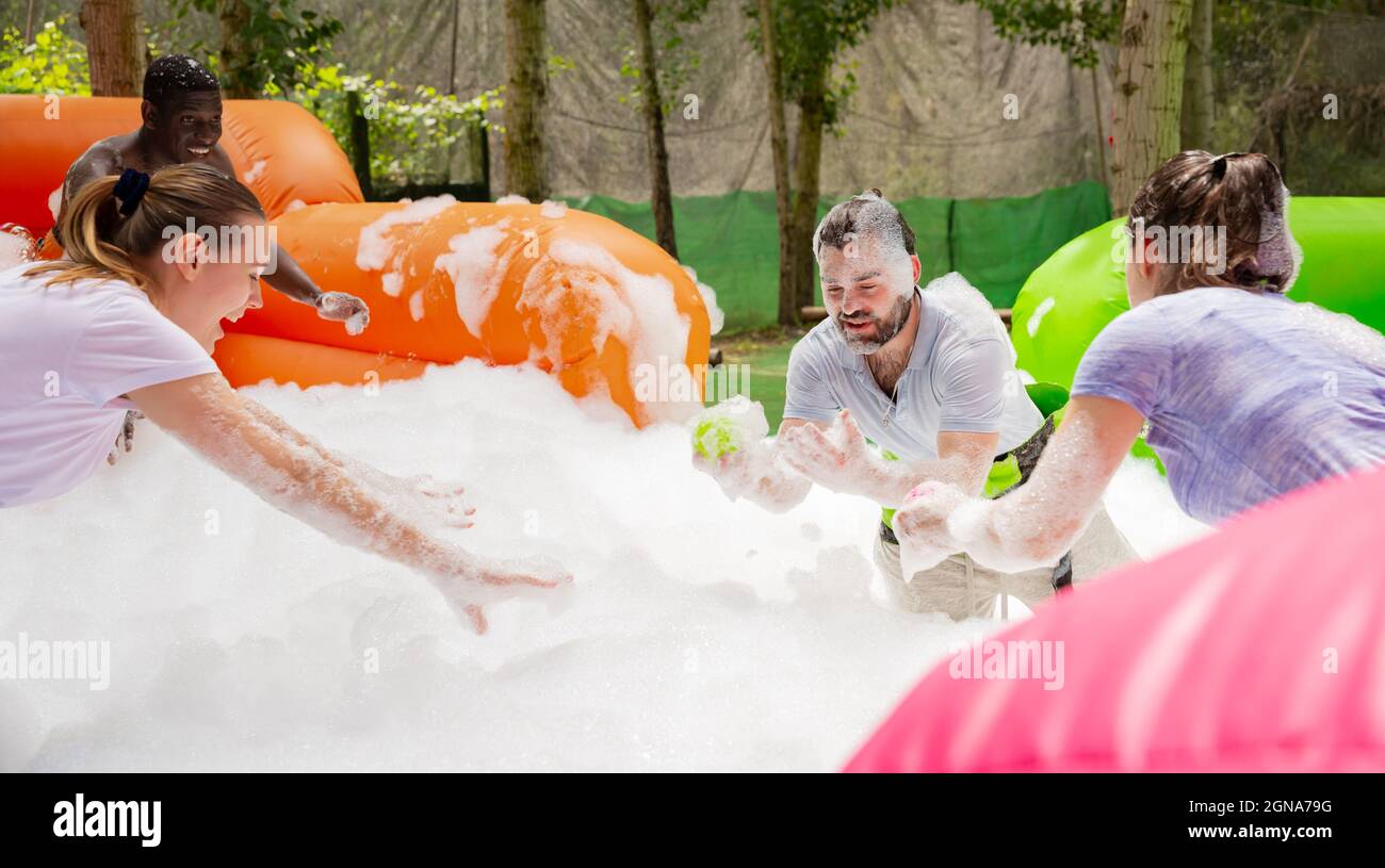 Happy friends are playing a game - who will find balls in soap suds ...
