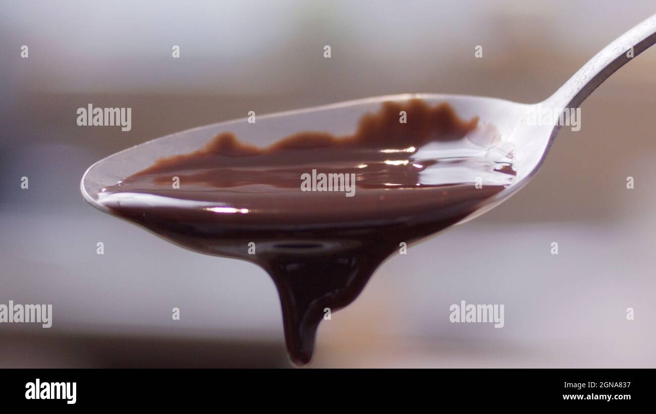 Liquid chocolate syrup driping dripping on spoon Stock Photo - Alamy