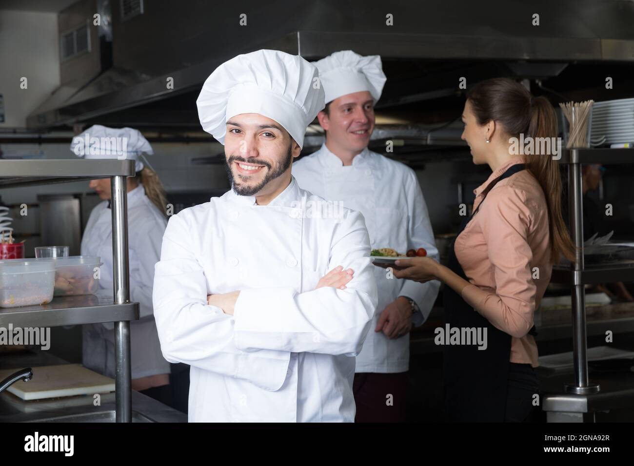 Chef in kitchen with busy staff Stock Photo - Alamy