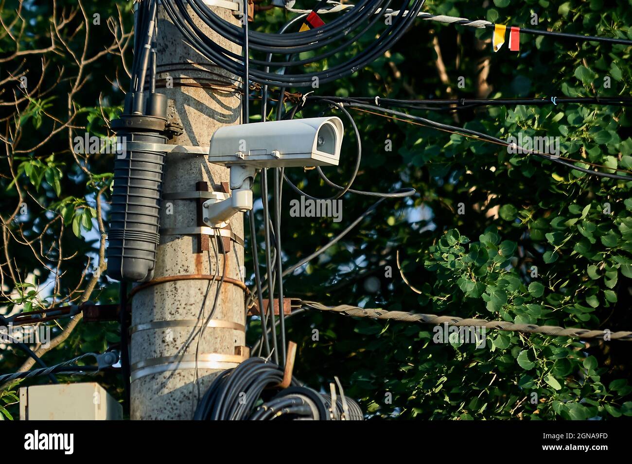 A security camera is hanging on a concrete post Stock Photo - Alamy