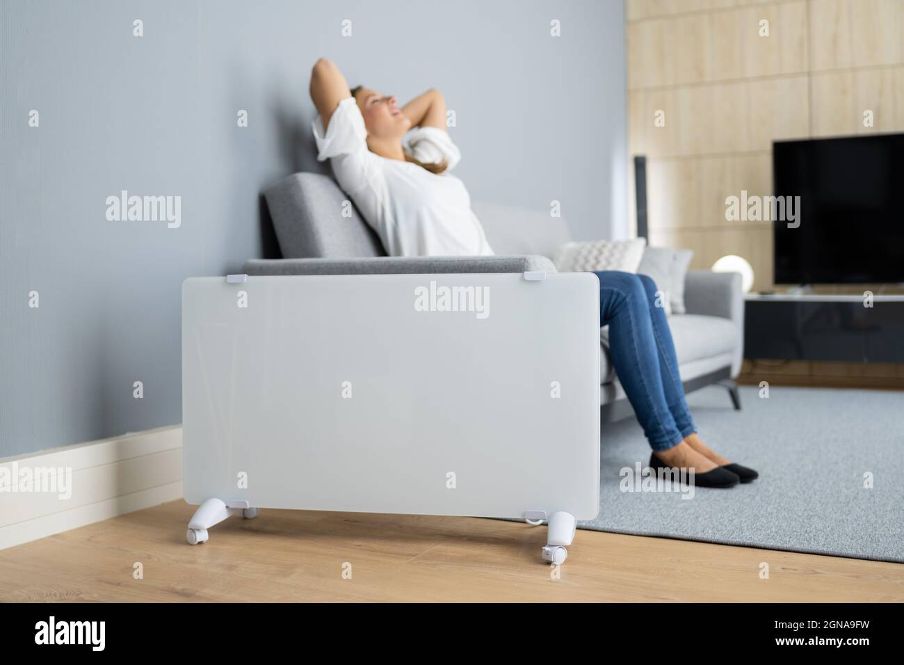 Happy Warm Woman Indoors Near Radiator Heater Stock Photo - Alamy