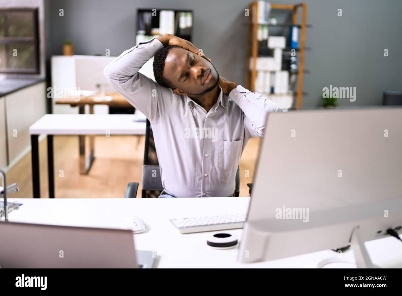 Employee Stretching At Office Desk At Work Stock Photo - Alamy