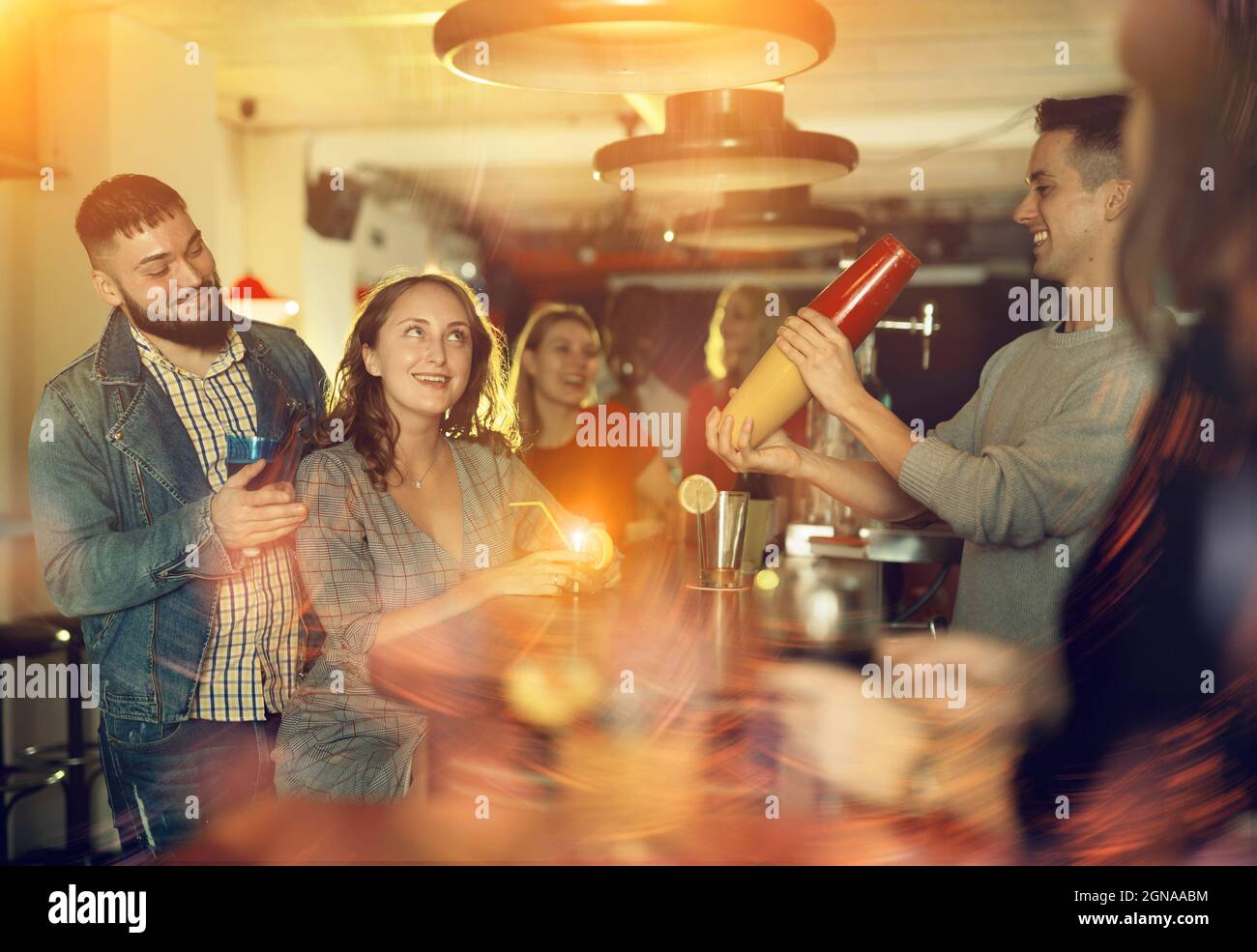 Man bartender shaking cocktail mixer for young people Stock Photo - Alamy