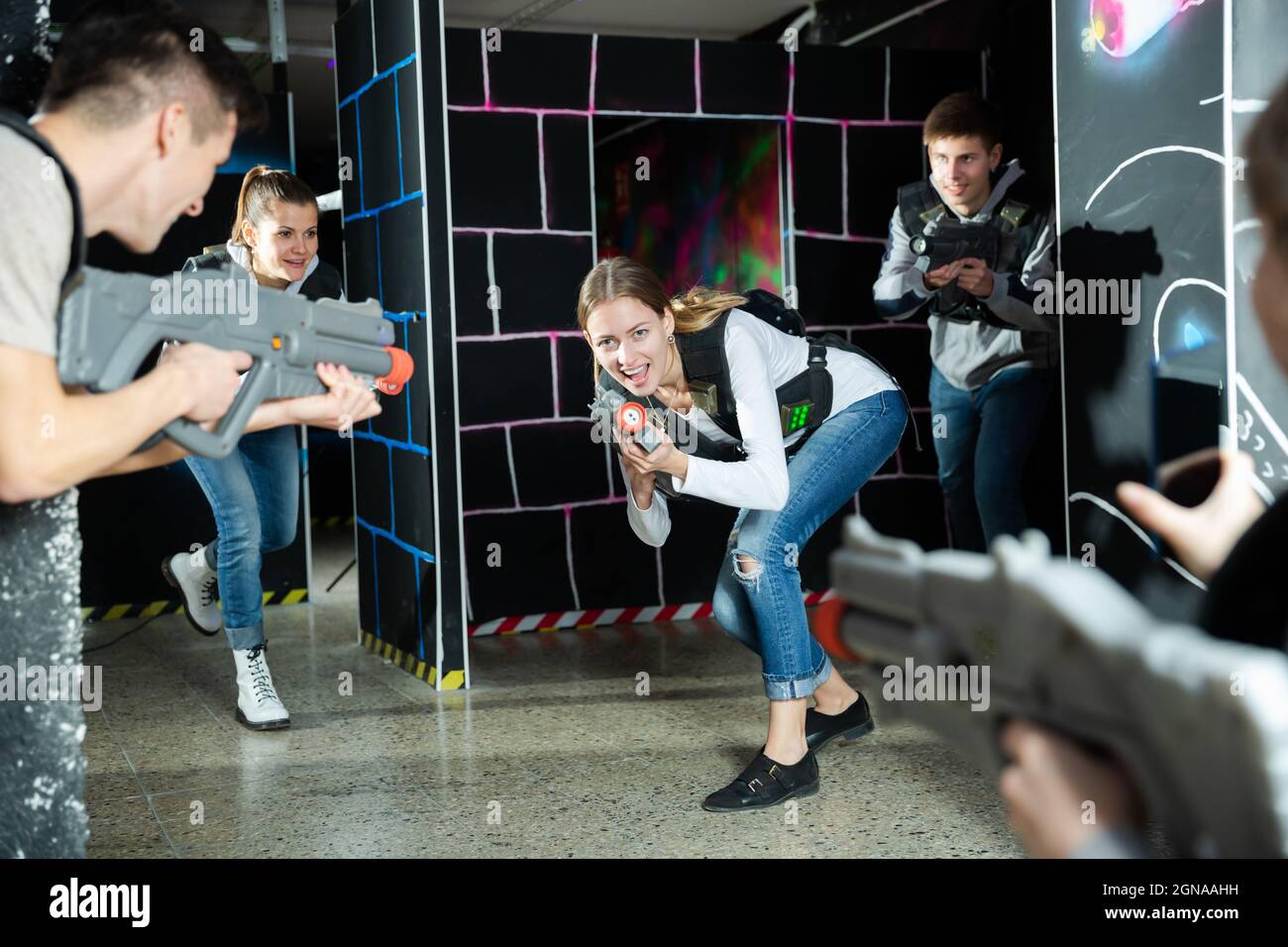 Girl playing laser tag with friends Stock Photo - Alamy