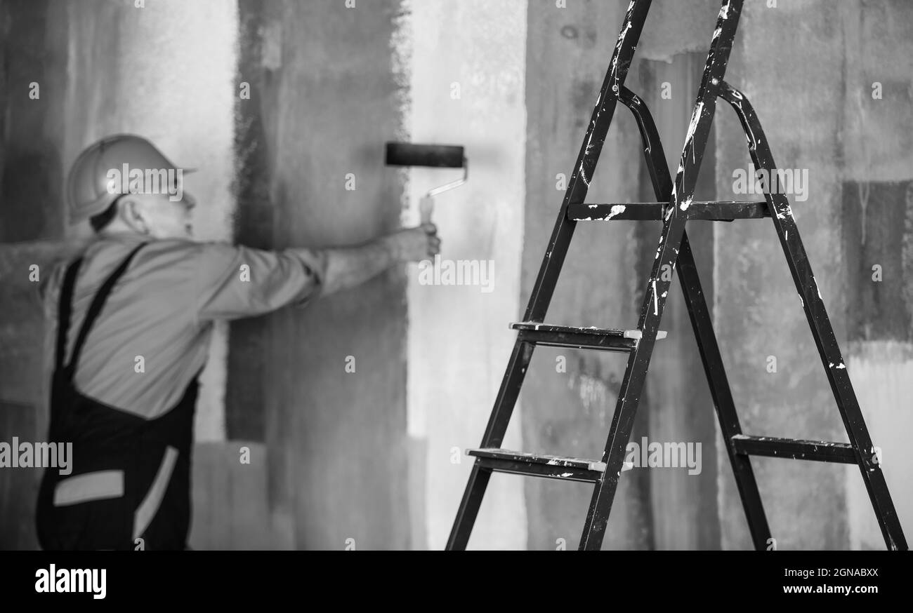 Painter man staircase. To make repairs. man in working clothes painting ...