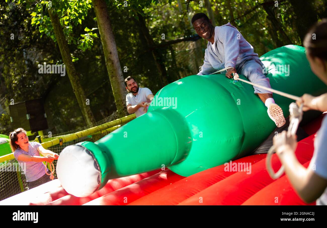 Attraction with a huge inflatable bottle - african-american man trying ...