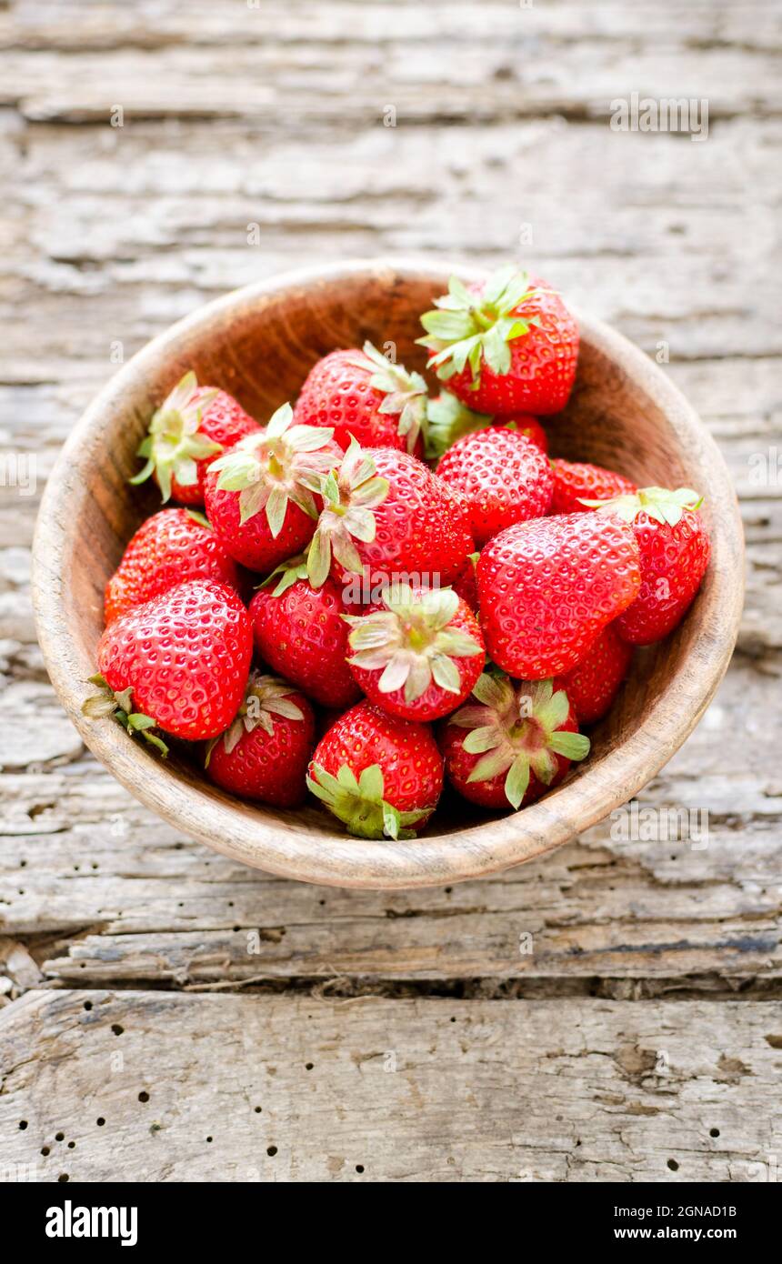 Freshly harvested strawberries. Wooden bowl filled with succulent juicy ...
