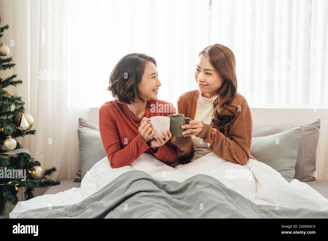 Two friends drinking coffee at home Stock Photo - Alamy
