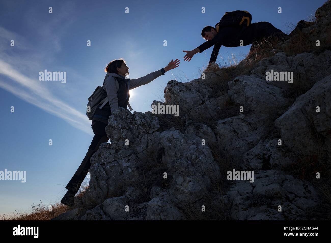 Help and assistance concept. Silhouettes of two people climbing ...