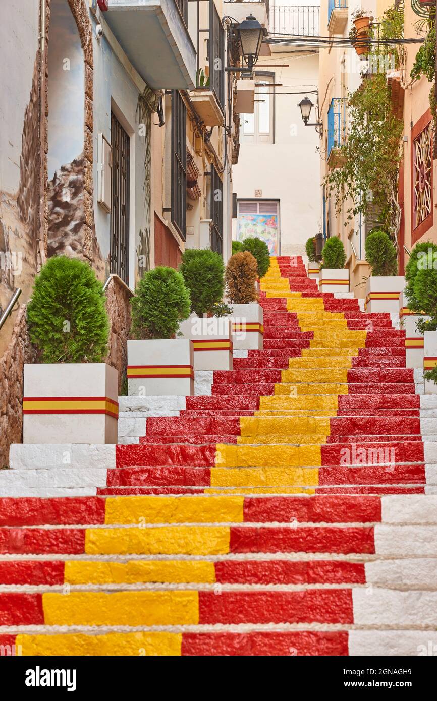 Picturesque stone street with spanish flag in Calpe. Spain Stock Photo ...