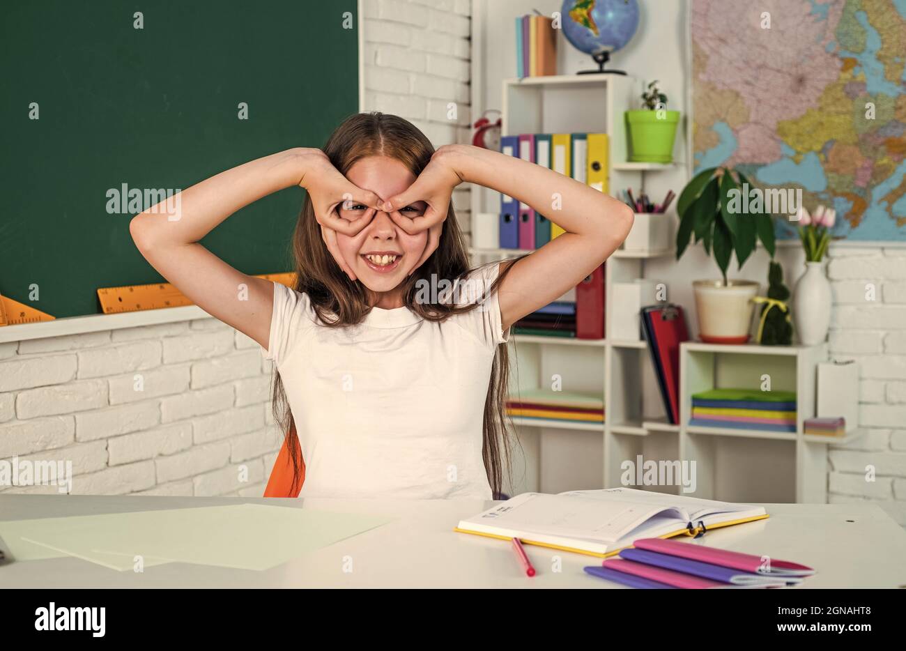smiling teen girl making faces in school classroom, having fun Stock ...