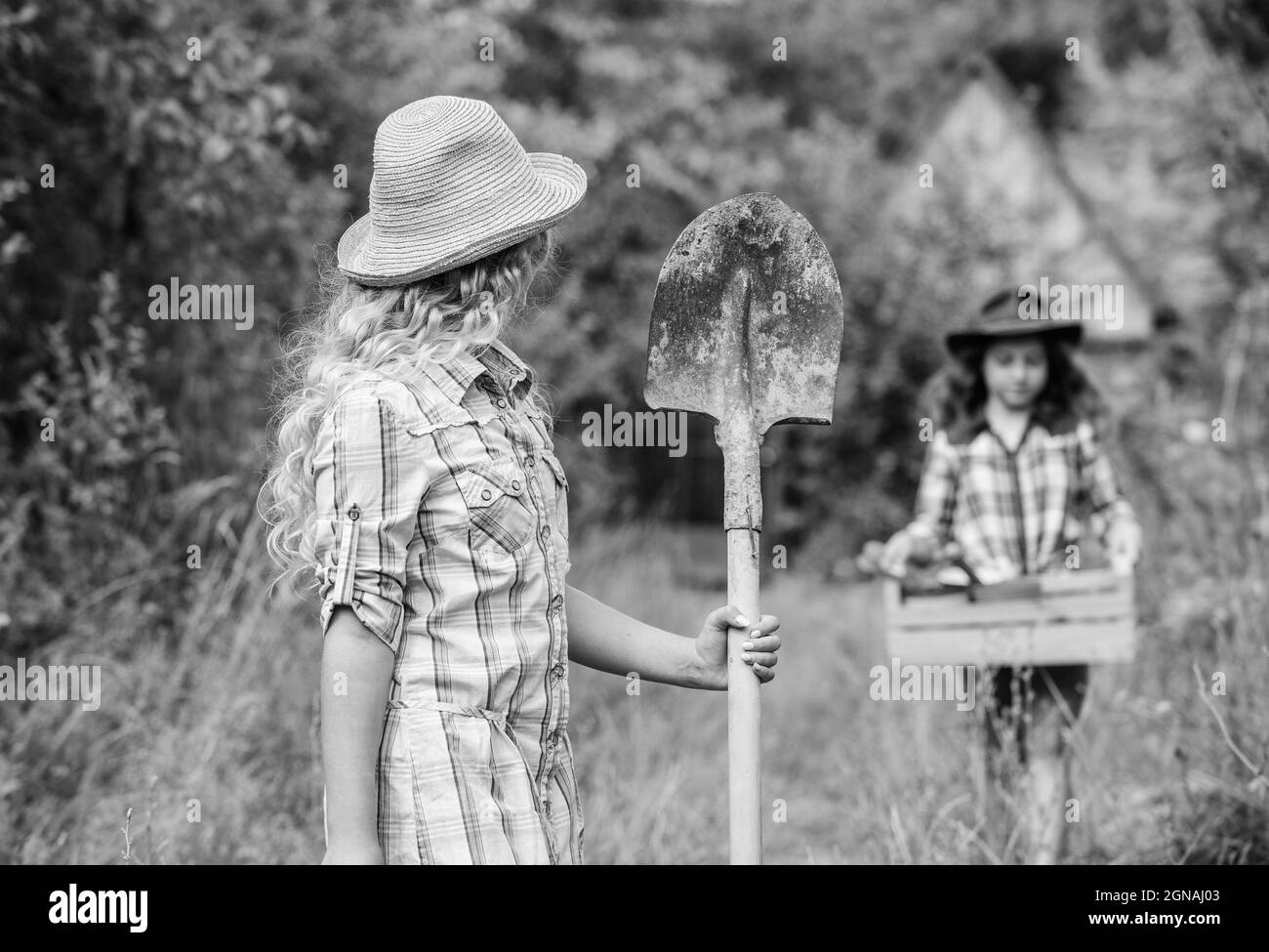 Girls with gardening tools. Summer at countryside. Sisters helping at ...