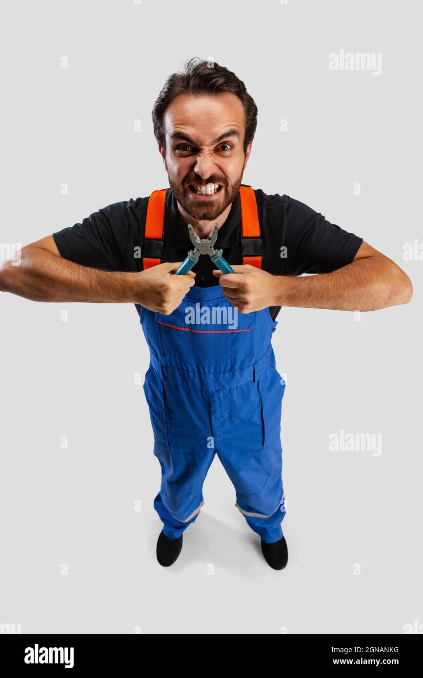 High angle view of young man, male auto mechanic or fitter in dungarees ...