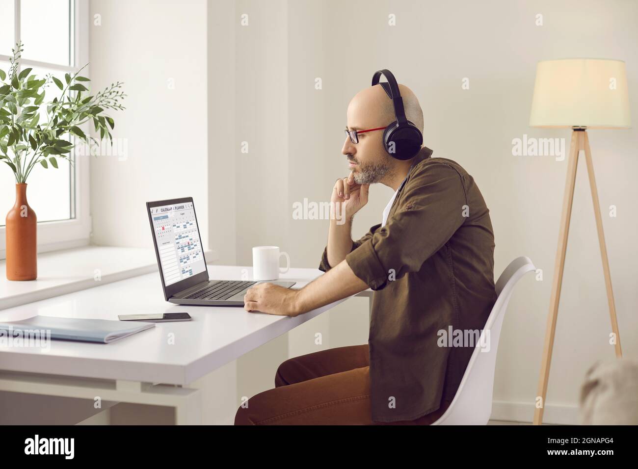 Man using digital calendar on laptop computer, thinking and planning ...