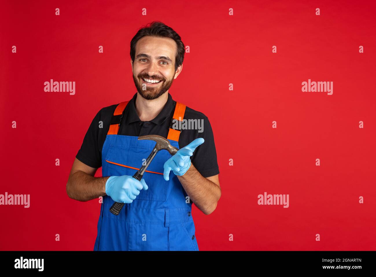 Funny young bearded man, male auto mechanic or fitter wearing blue work ...