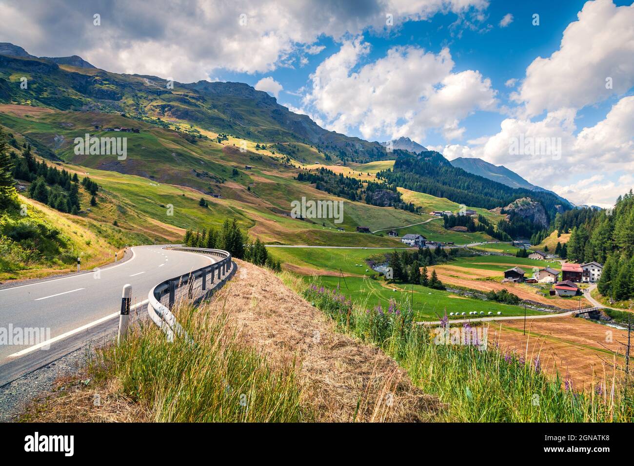 Empty asphalt road with colorful cloudy sky in the Swiss Alps ...