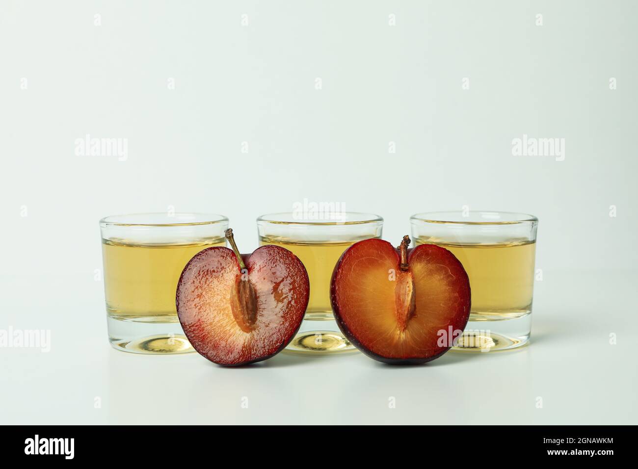 Plum vodka shots and ingredients on white background Stock Photo - Alamy