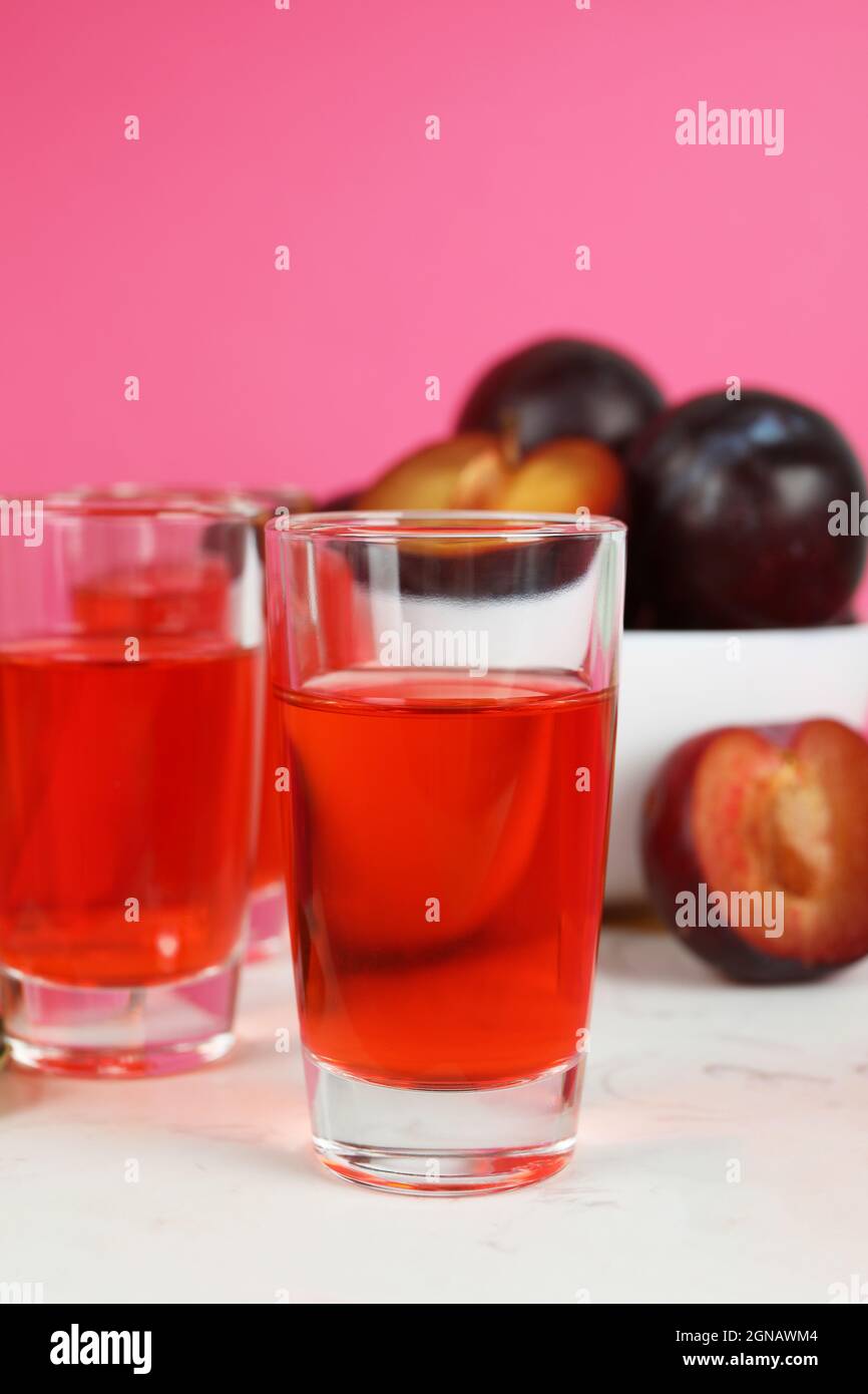 Plum brandy shots and ingredients on pink background Stock Photo - Alamy
