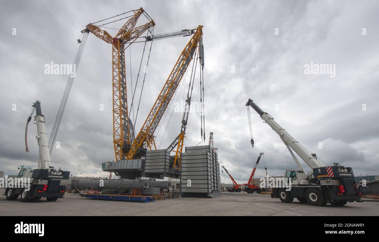 Ehingen, Germany. 26th Aug, 2021. Two truck-mounted cranes stand next ...