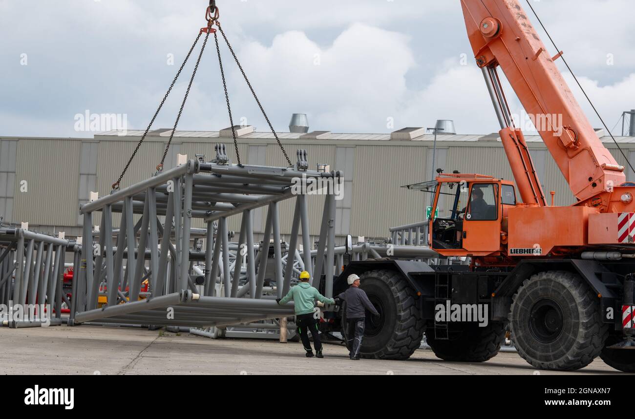 Ehingen, Germany. 26th Aug, 2021. Workers move parts of a mobile crane ...