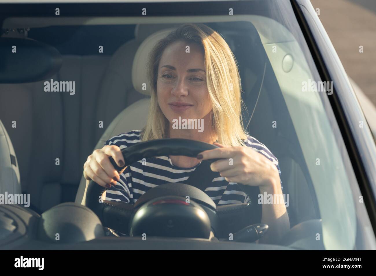 Female in car. Experienced confident woman driver holding steering ...
