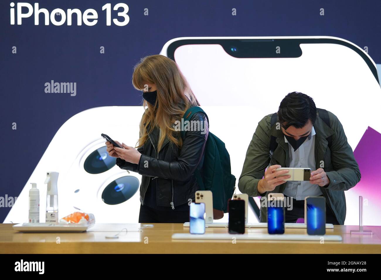 Customers look at the new Apple iPhone 13 at the tech giant's flagship ...