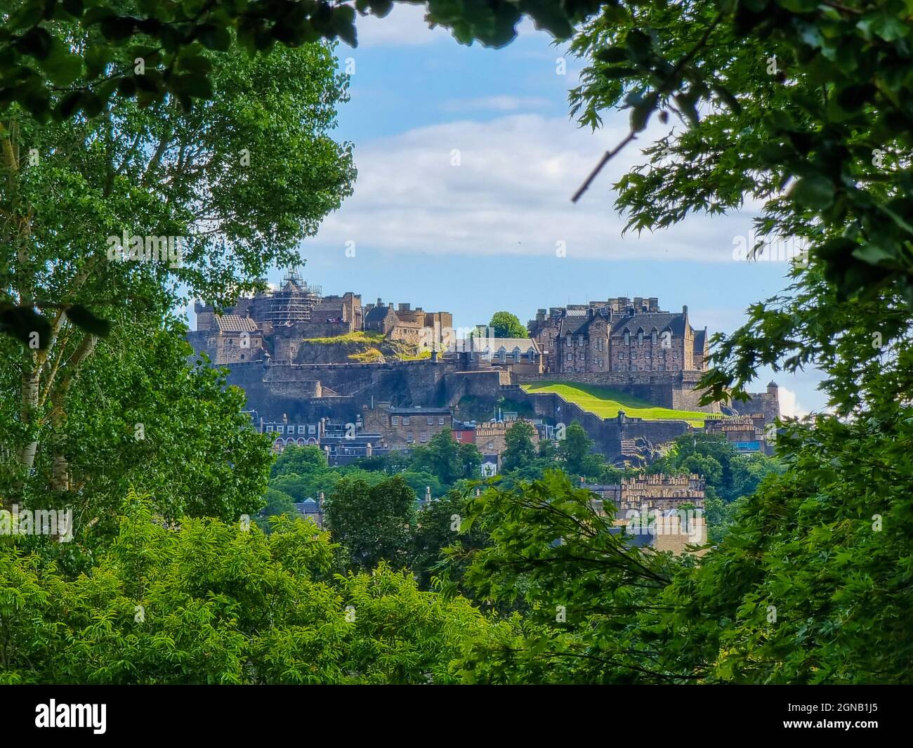 Trees frame Edinburgh castle from distance Stock Photo - Alamy
