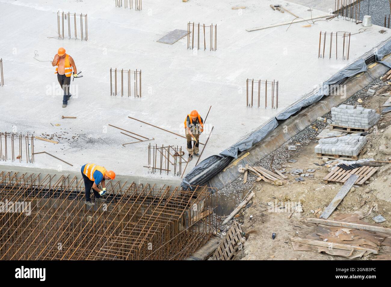 concreting work: construction site worker during concrete pouring into ...