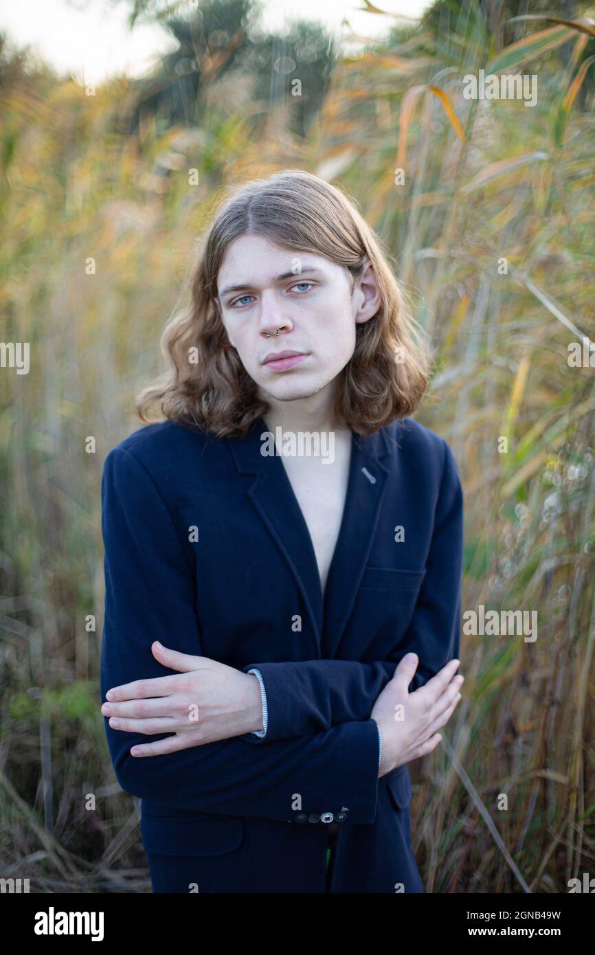 White man with long hair in dark clothes in nature Stock Photo - Alamy