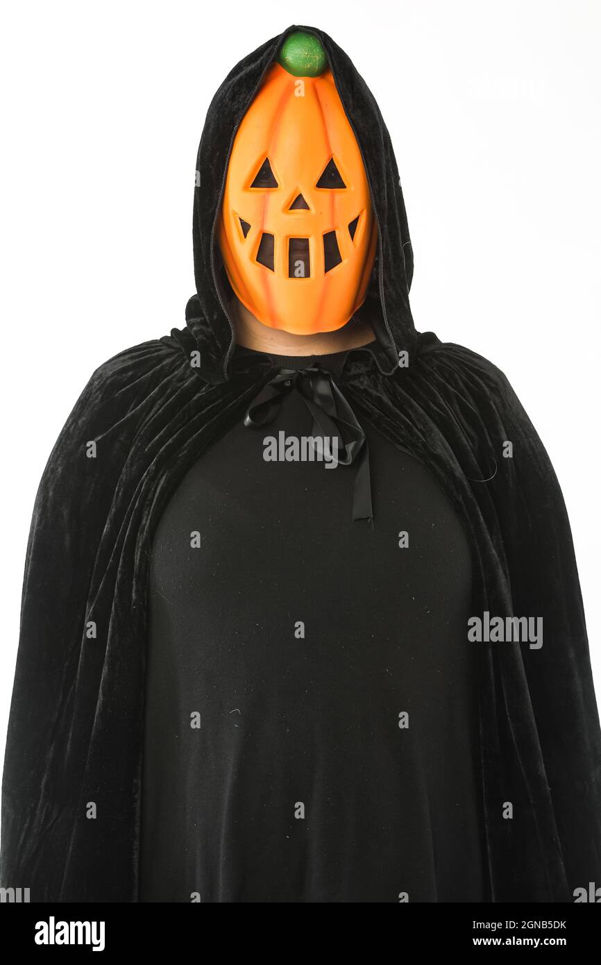 Person wearing pumpkin Jack-o.-lantern mask and hooded velvet cape, on ...