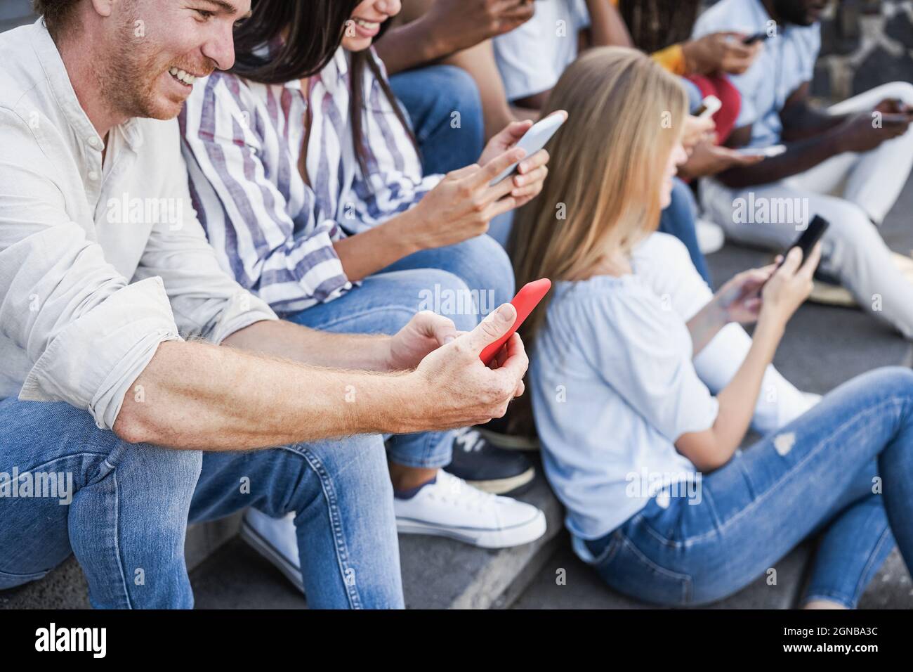 Young happy people using mobile phones outdoor in the city - Focus on ...