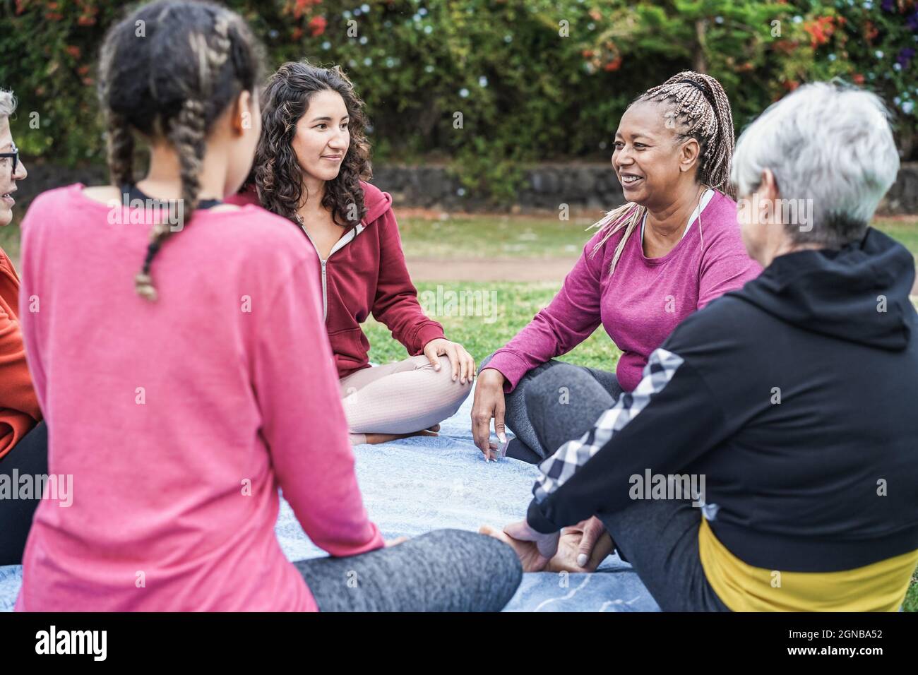 Multi generational women having fun together sitting outdoors at city ...