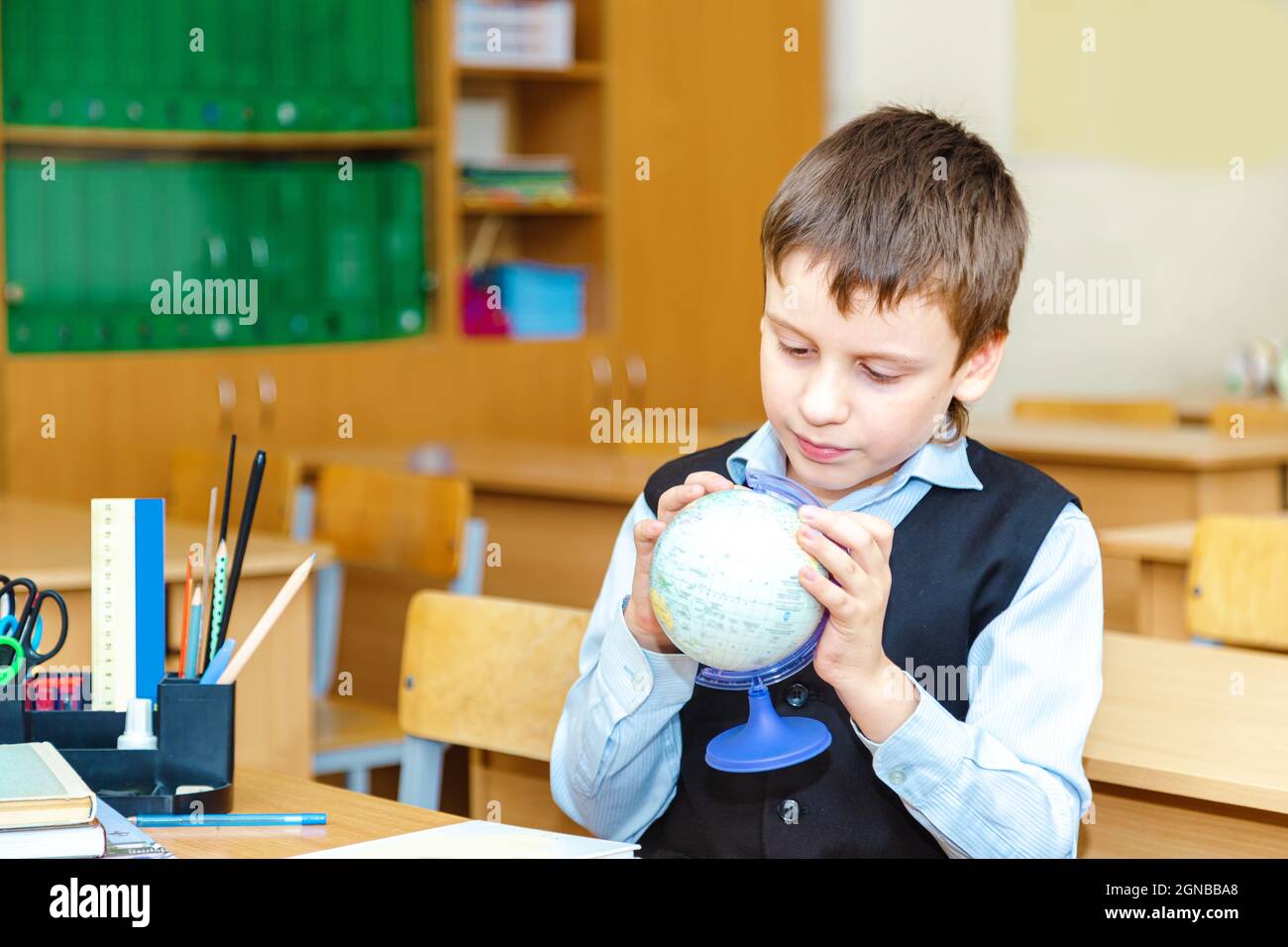 Serious schoolboy in the classroom. Primary school student. Back to ...